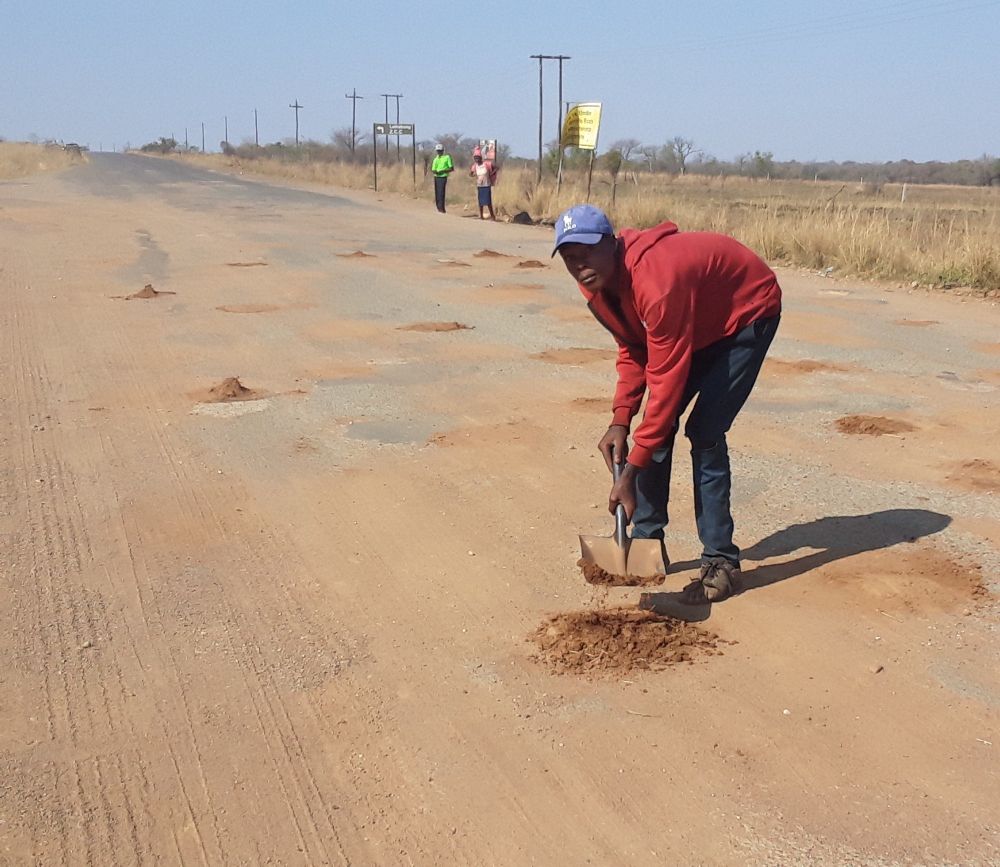 Pothole crisis: Man risks life filling potholes with sand for some coins