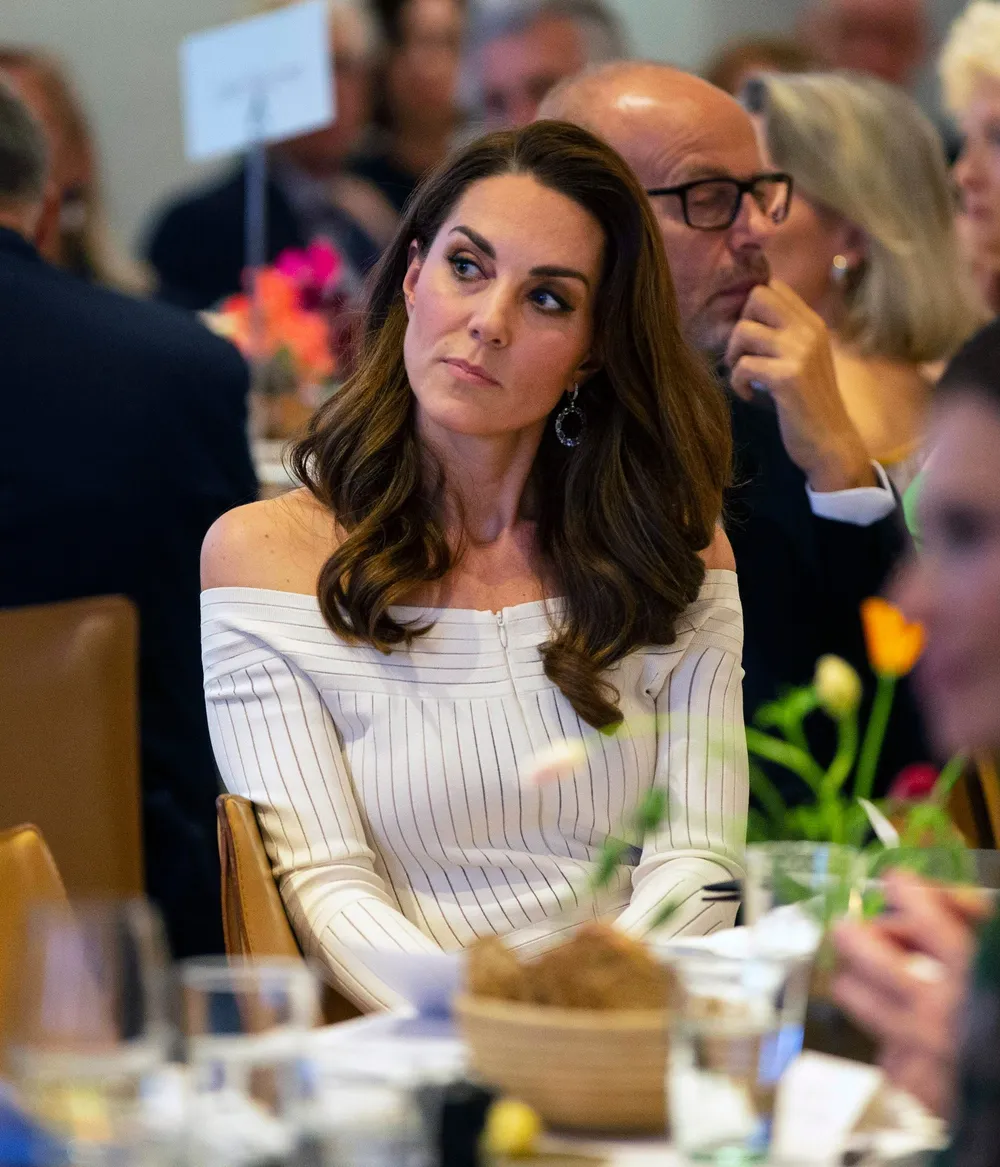 Duchess Kate braves the elements in a white off-the-shoulder dress