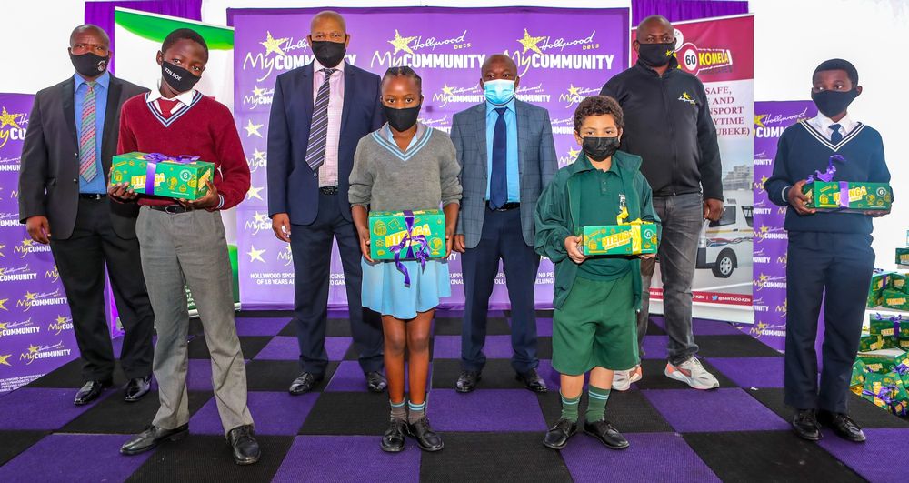 A trio of generous givers hand over more than 900 pairs of school shoes