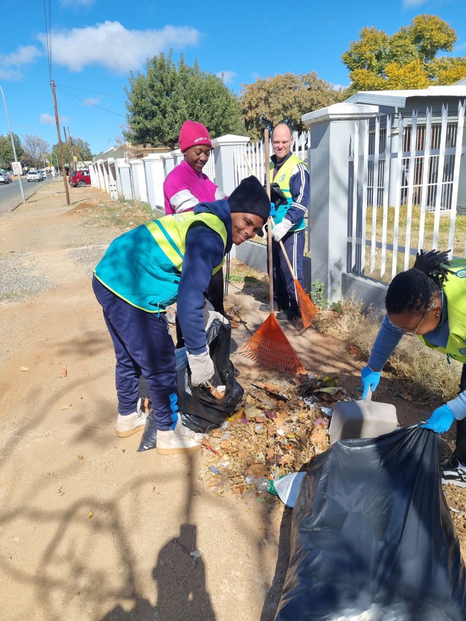Youths and volunteers clean up city street