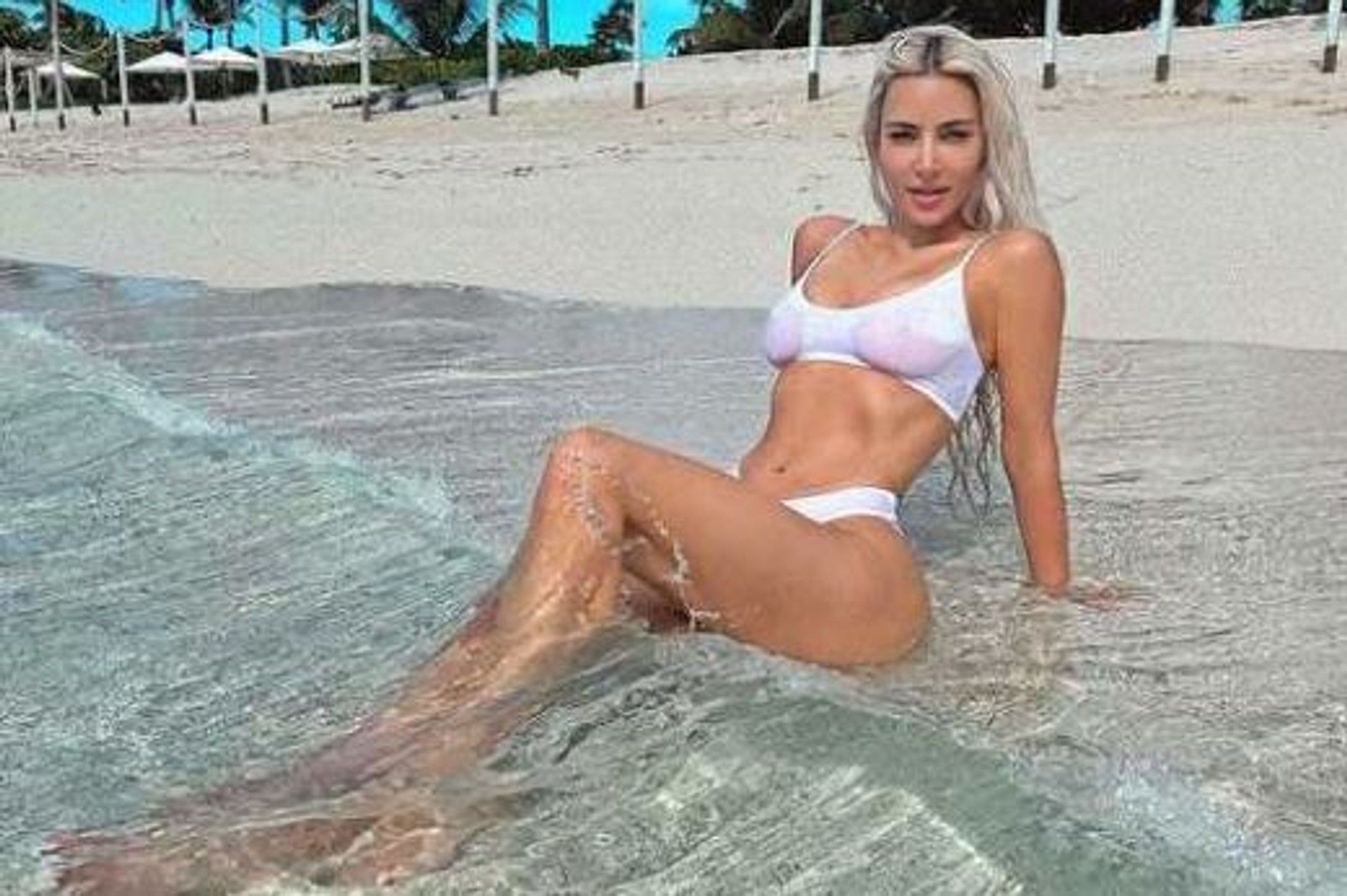Kyk jy iets mis? Kim bares all in skimpy ‘bikini’ on beach shoot