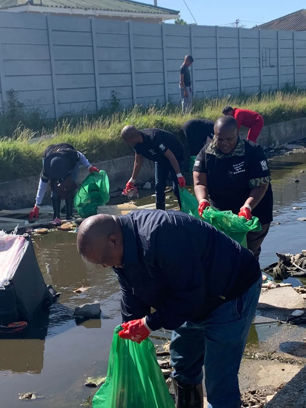 Legislators get their hands dirty cleaning up a canal in Hazendal